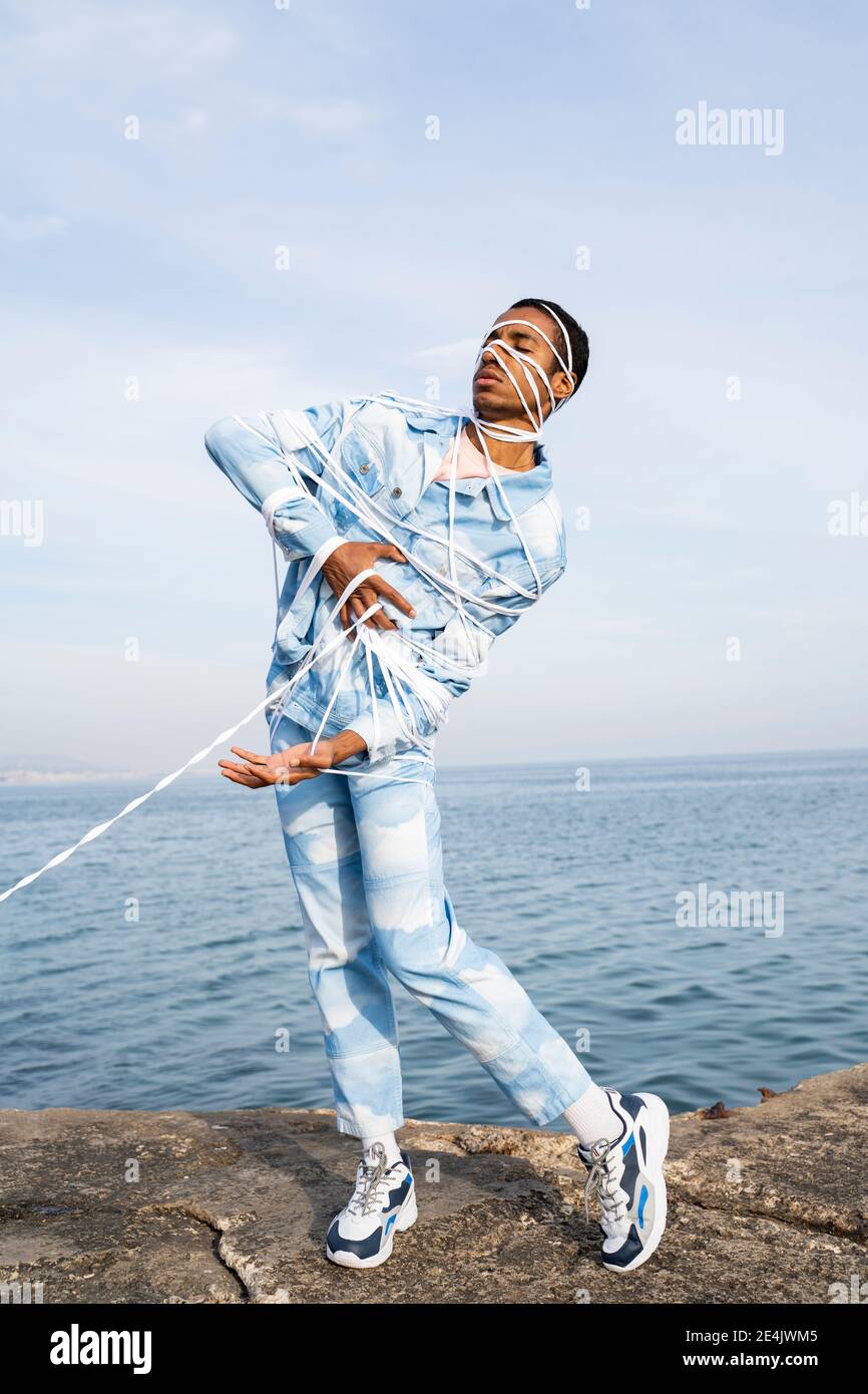 Man trapped in rope struggling while standing against sea Stock Photo ...