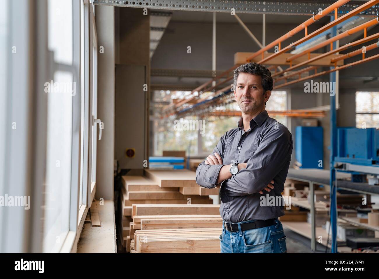 Portrait of carpenter posing in production hall with crossed arms Stock ...