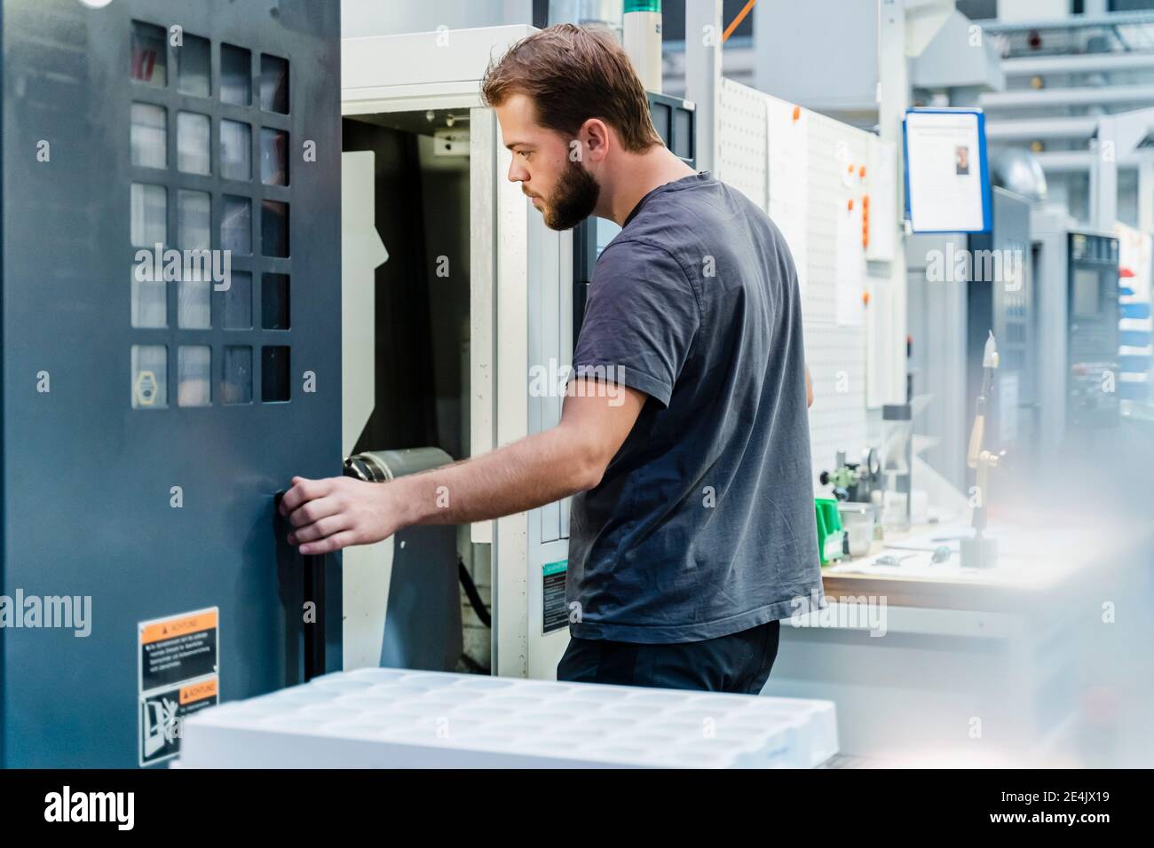 Maintenance engineer operating machine while standing at factory Stock ...
