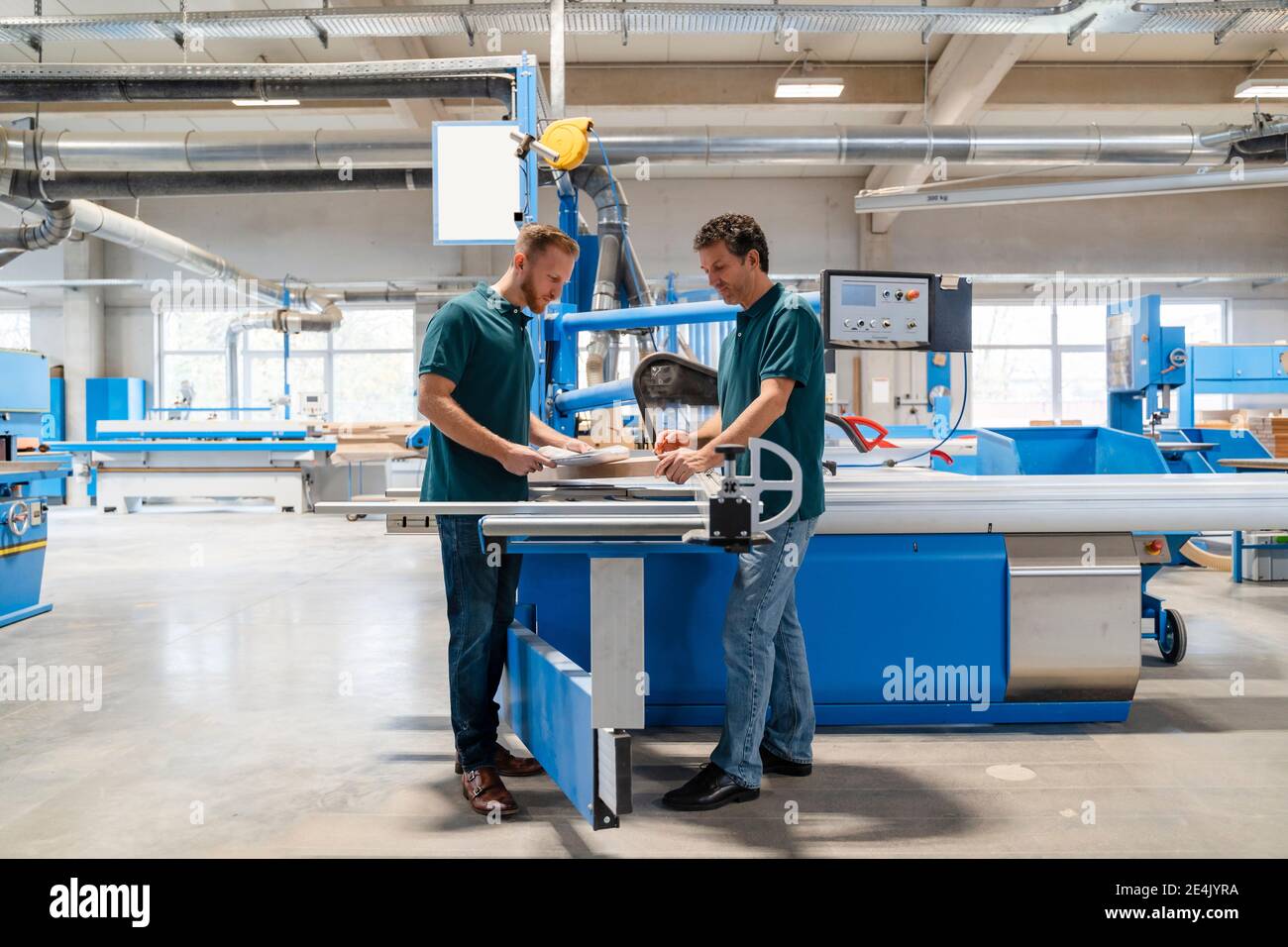 Two male carpenters working together in production hall Stock Photo - Alamy