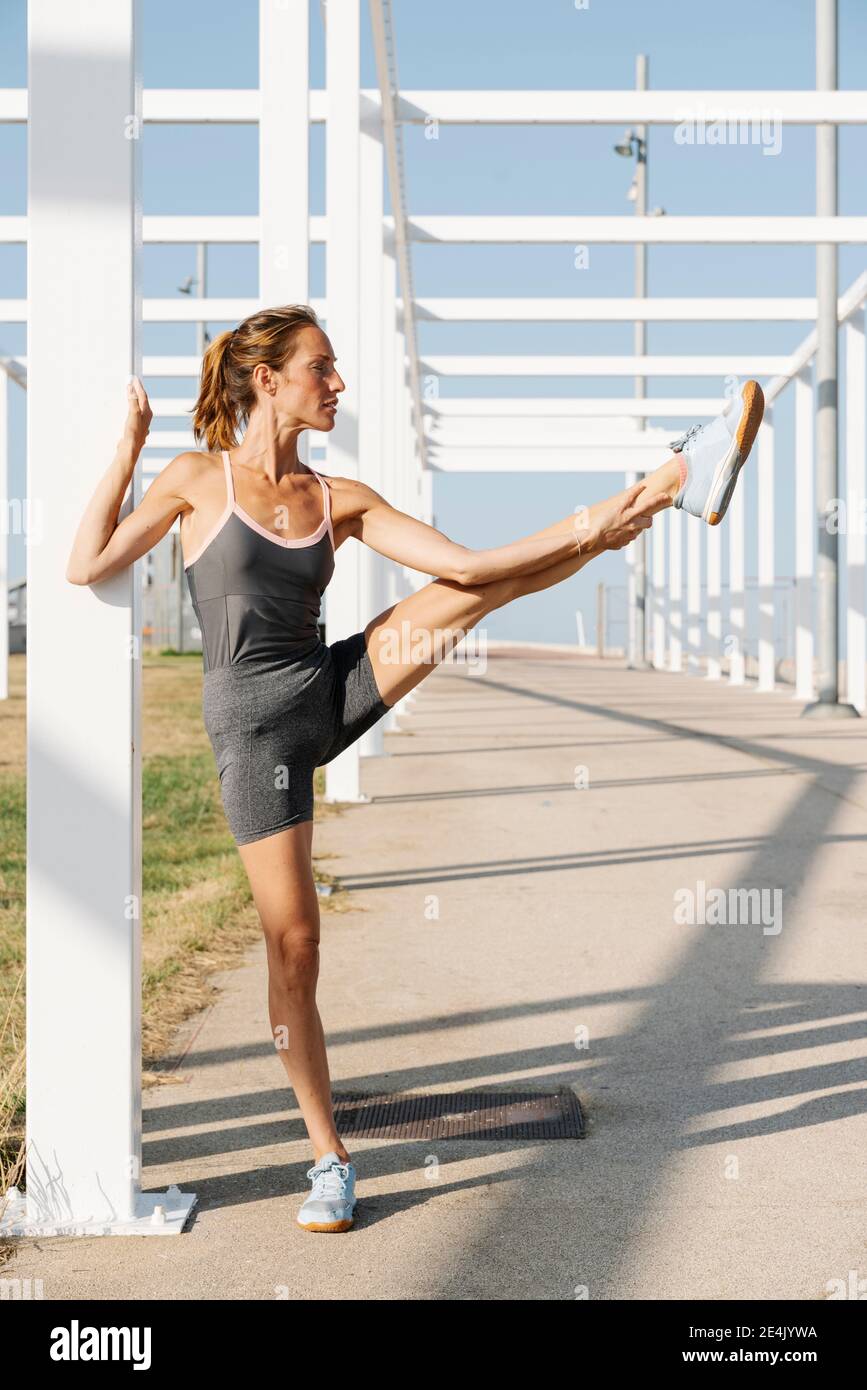 Female sportsperson doing warm up exercise on sunny day Stock Photo - Alamy