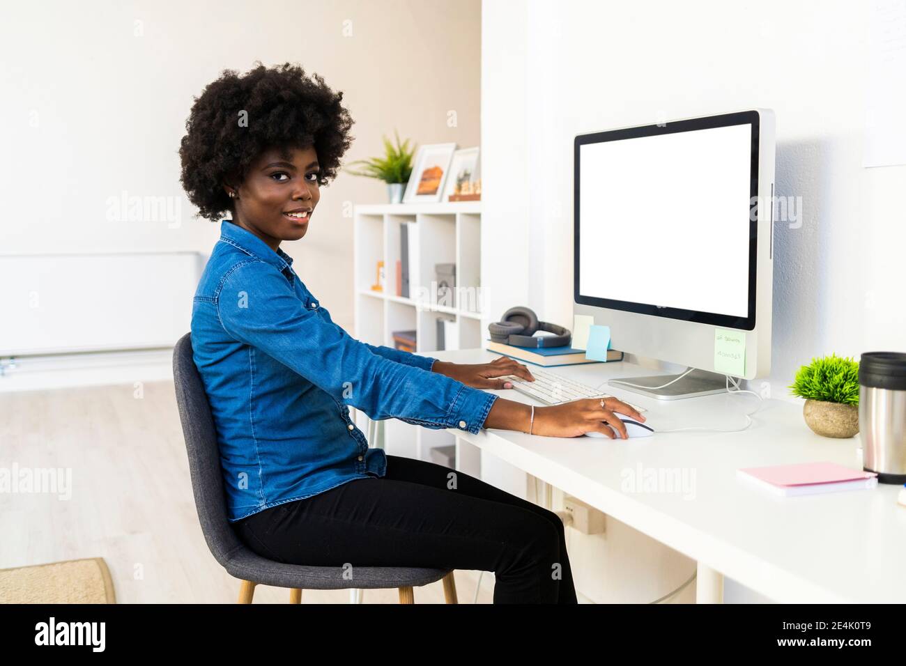 Young woman sitting by computer hi-res stock photography and images - Alamy