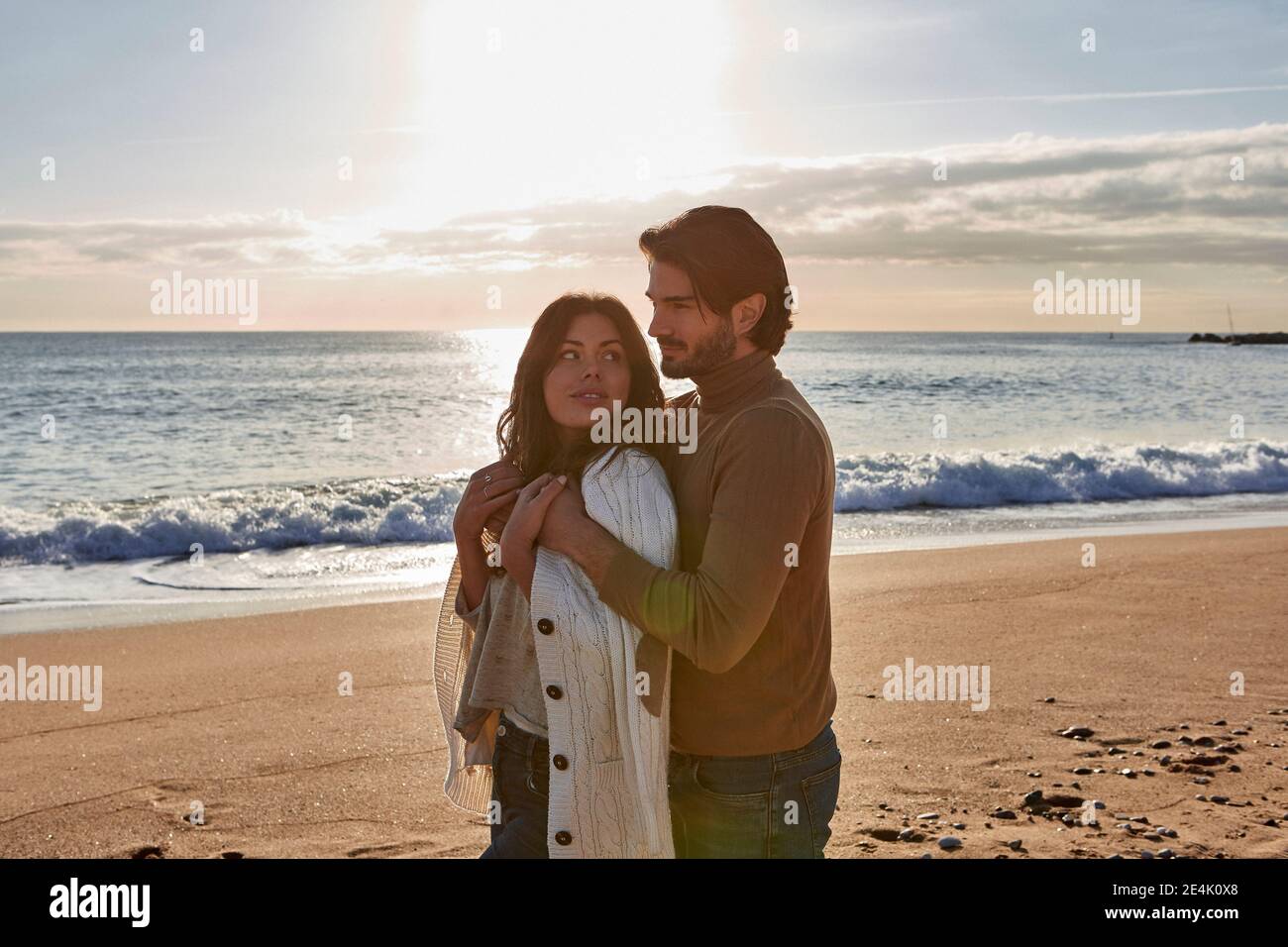 Boyfriend hugging girlfriend while standing against sea Stock Photo - Alamy
