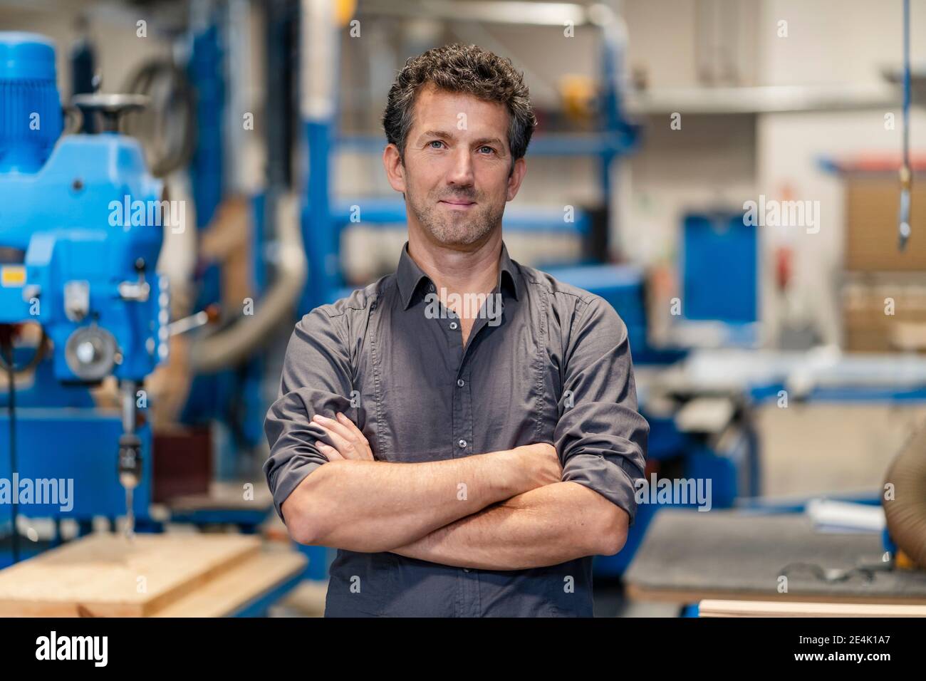 Portrait of carpenter posing with crossed arms Stock Photo - Alamy