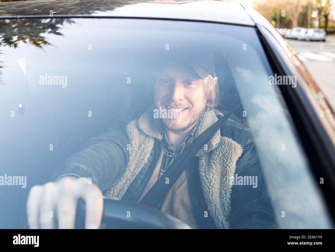 Smiling mid adult man driving car seen through windshield Stock Photo ...