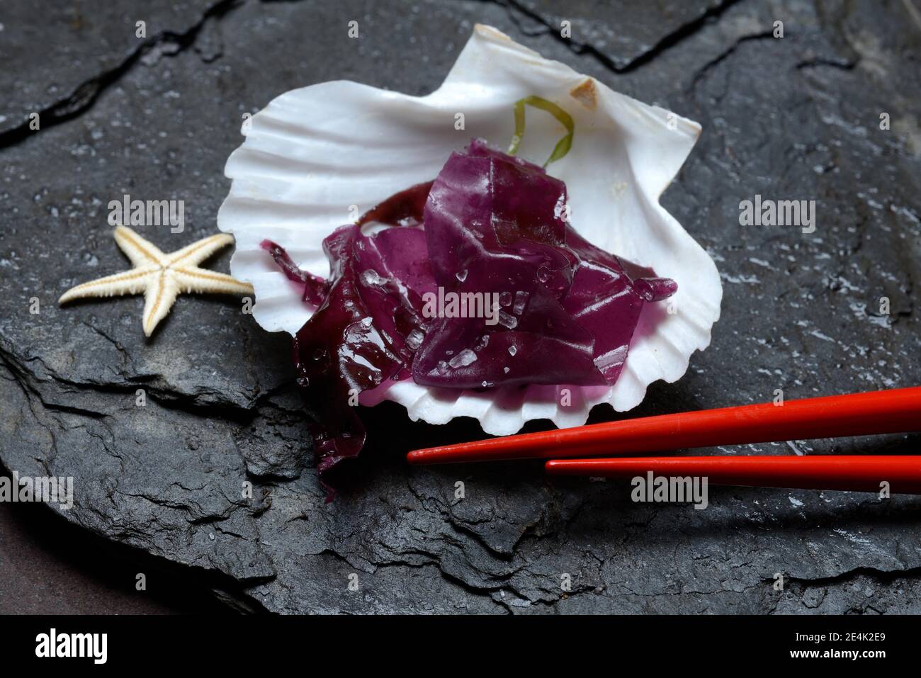 Red alga with sea salt in mussel shell and chopsticks, Palmaria palmata ...