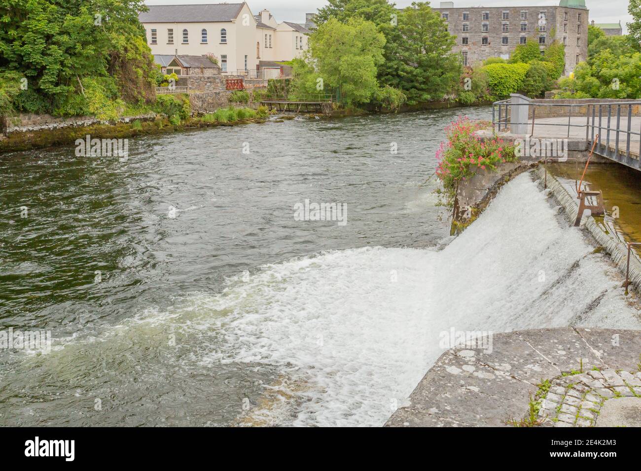 Water entering the Corrib river through a small dam forming a waterfall ...