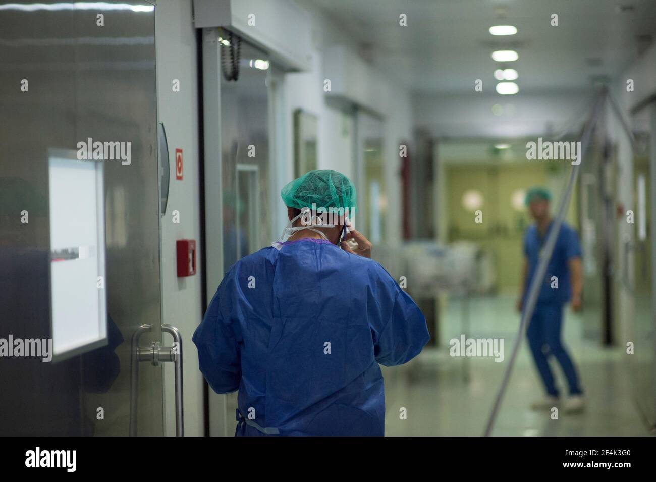 Male orthopedic surgeon seen through glass window while operating in ...