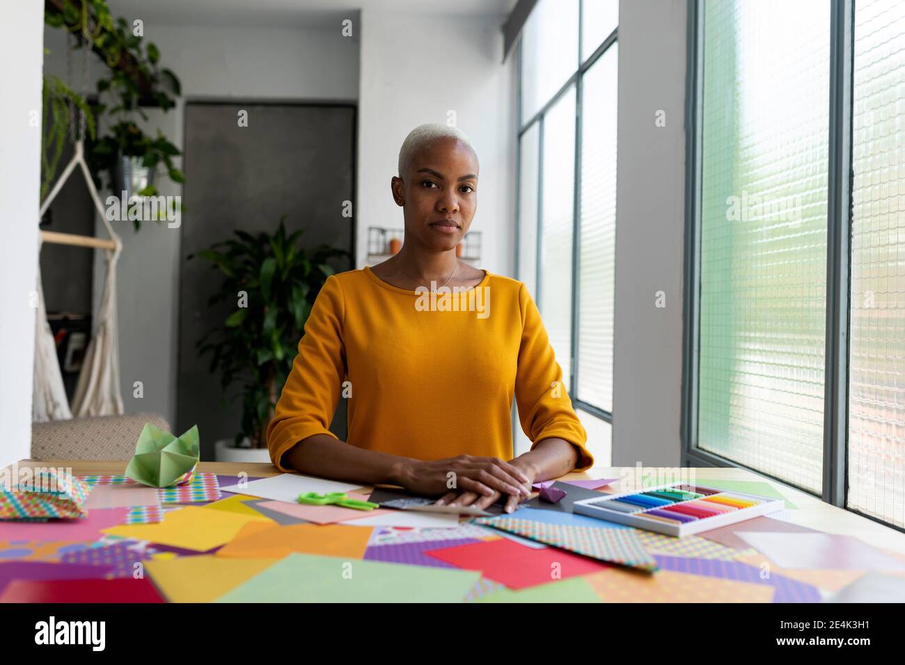 Origami artist sitting in studio with colorful papers Stock Photo - Alamy