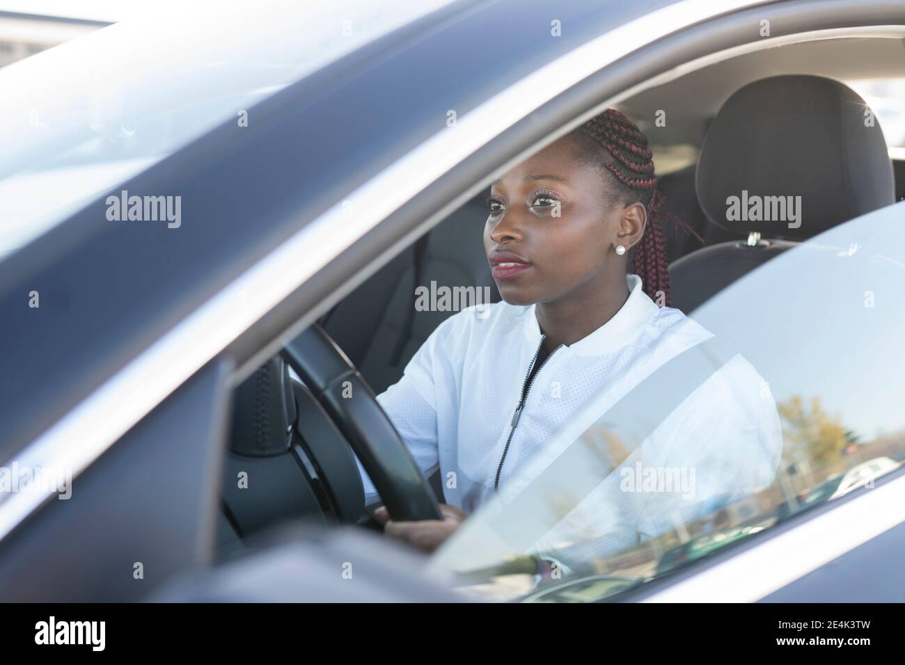 Young woman seen through window while driving car Stock Photo - Alamy