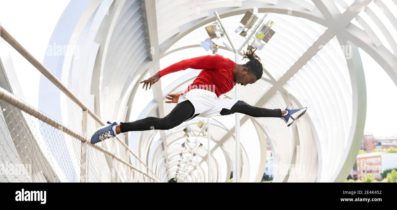 Acrobat jumping while exercising on walkway Stock Photo - Alamy