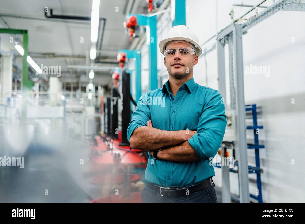 Confident male engineer with arms crossed in industry Stock Photo - Alamy