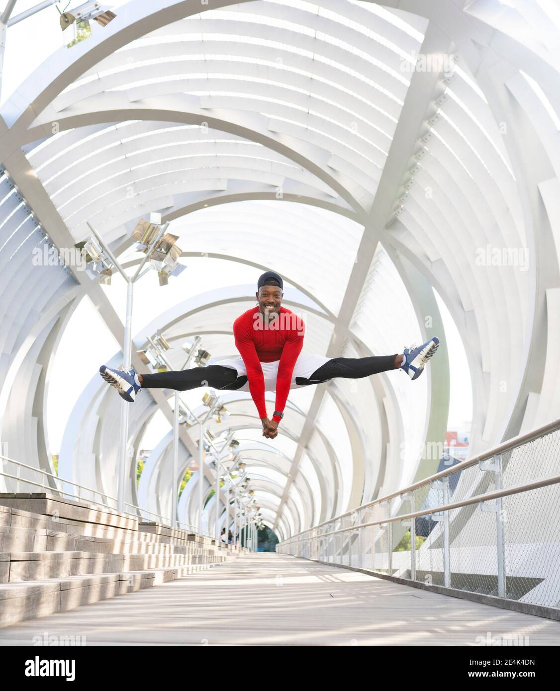 Acrobat jumping while doing the splits on walkway Stock Photo - Alamy