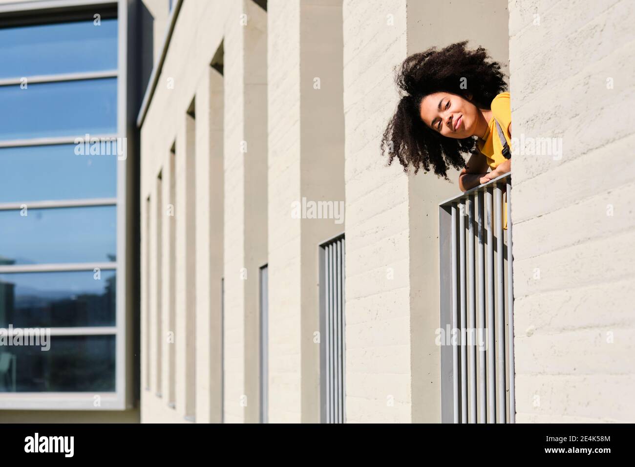 Young woman leaning on railing at university Stock Photo - Alamy
