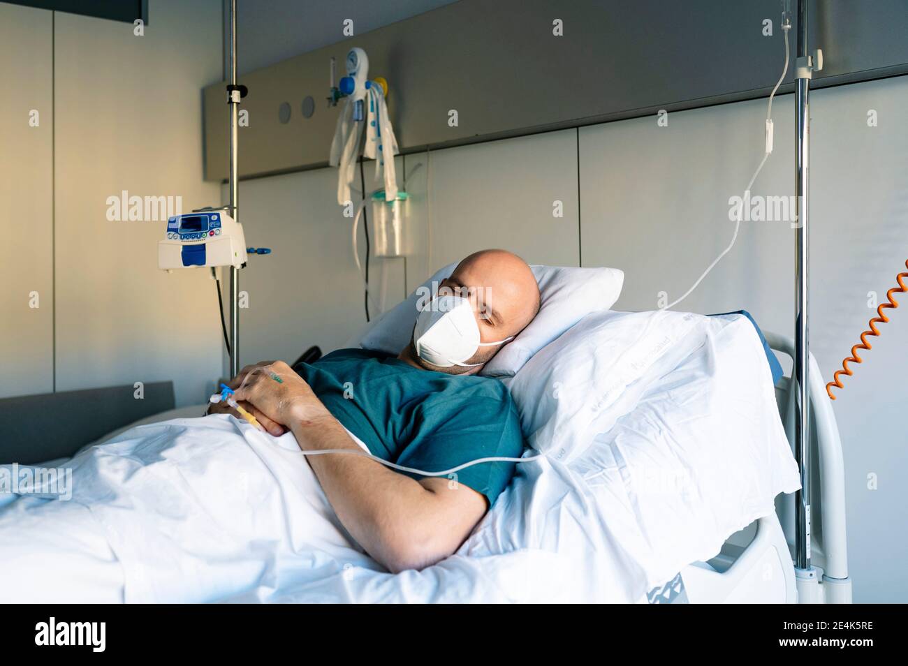 Patient with IV drip using mobile phone while lying on bed in hospital ... Patient with IV drip using mobile phone while lying on bed in hospital ...