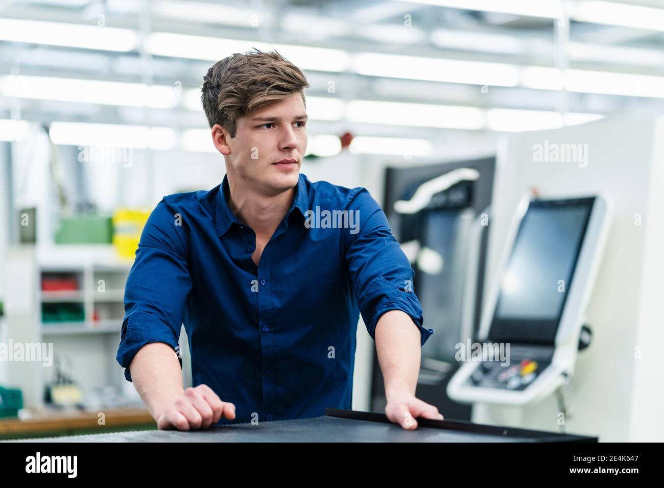 Male engineer day dreaming while standing in industry Stock Photo - Alamy