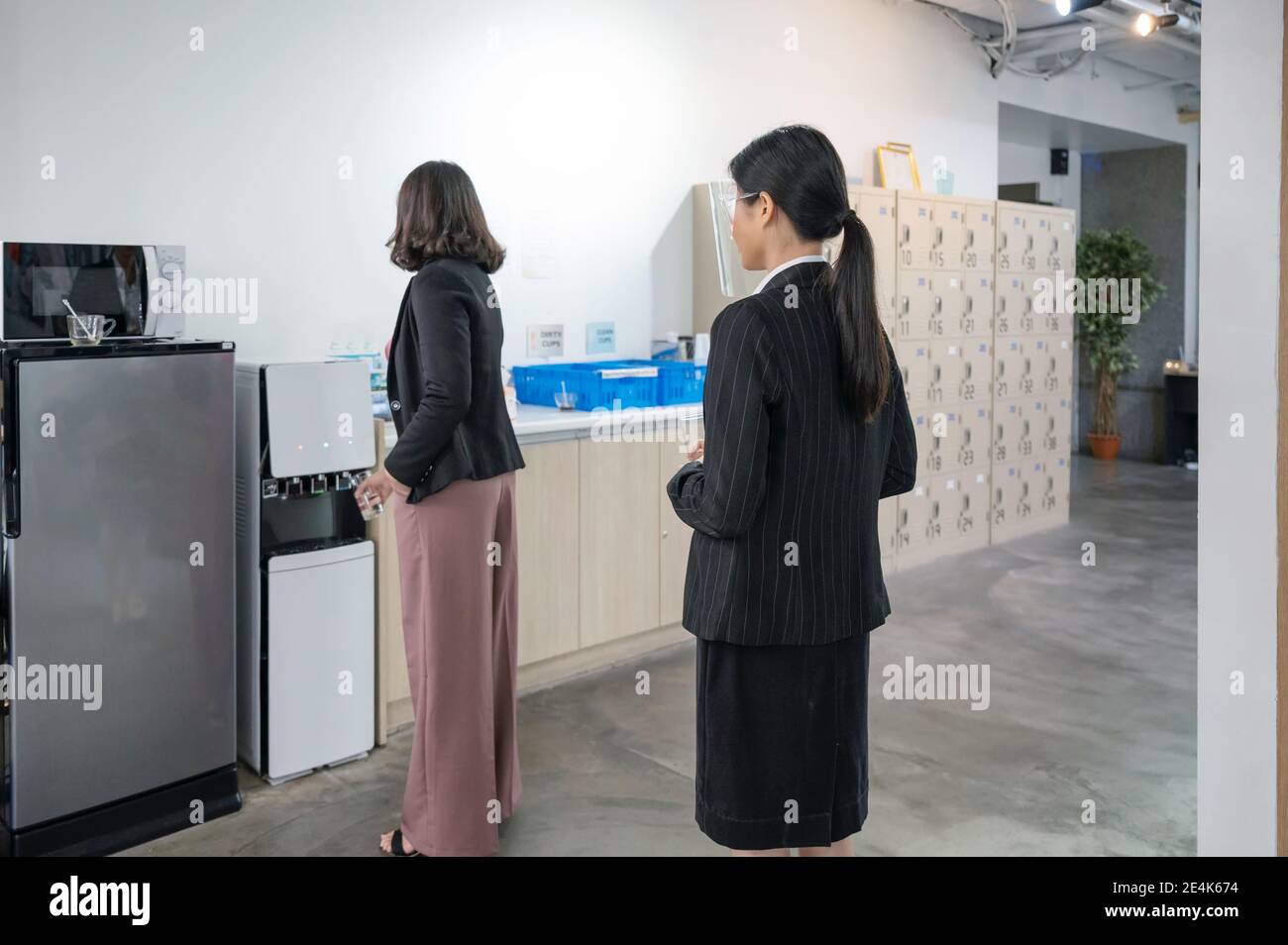 Office employee standing in queue up to drink water form water ...