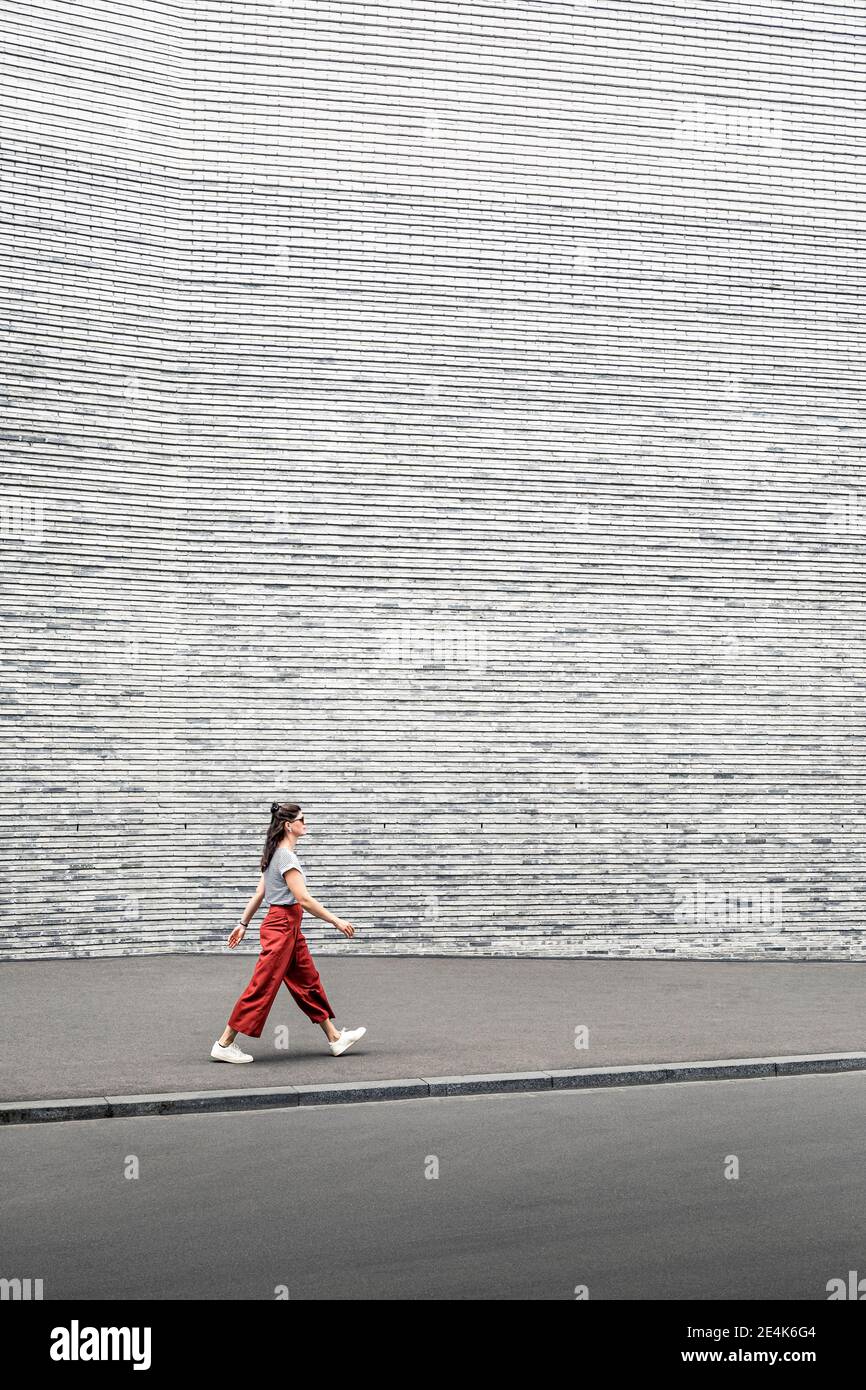 Woman walking sidewalk gray wall hi-res stock photography and images ...