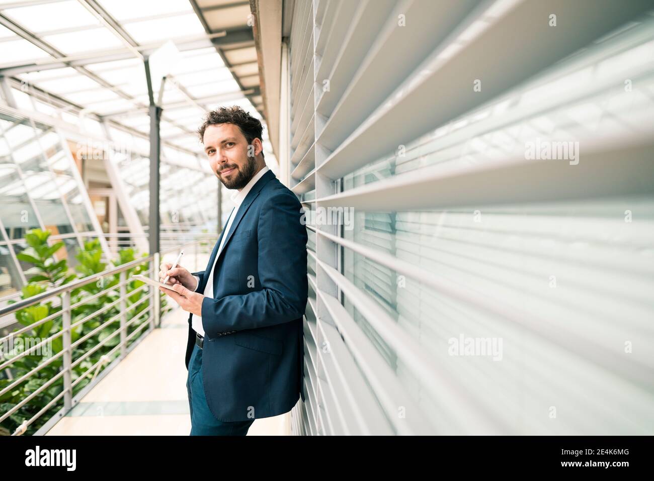 Businessman standing smiling against green hi-res stock photography and ...