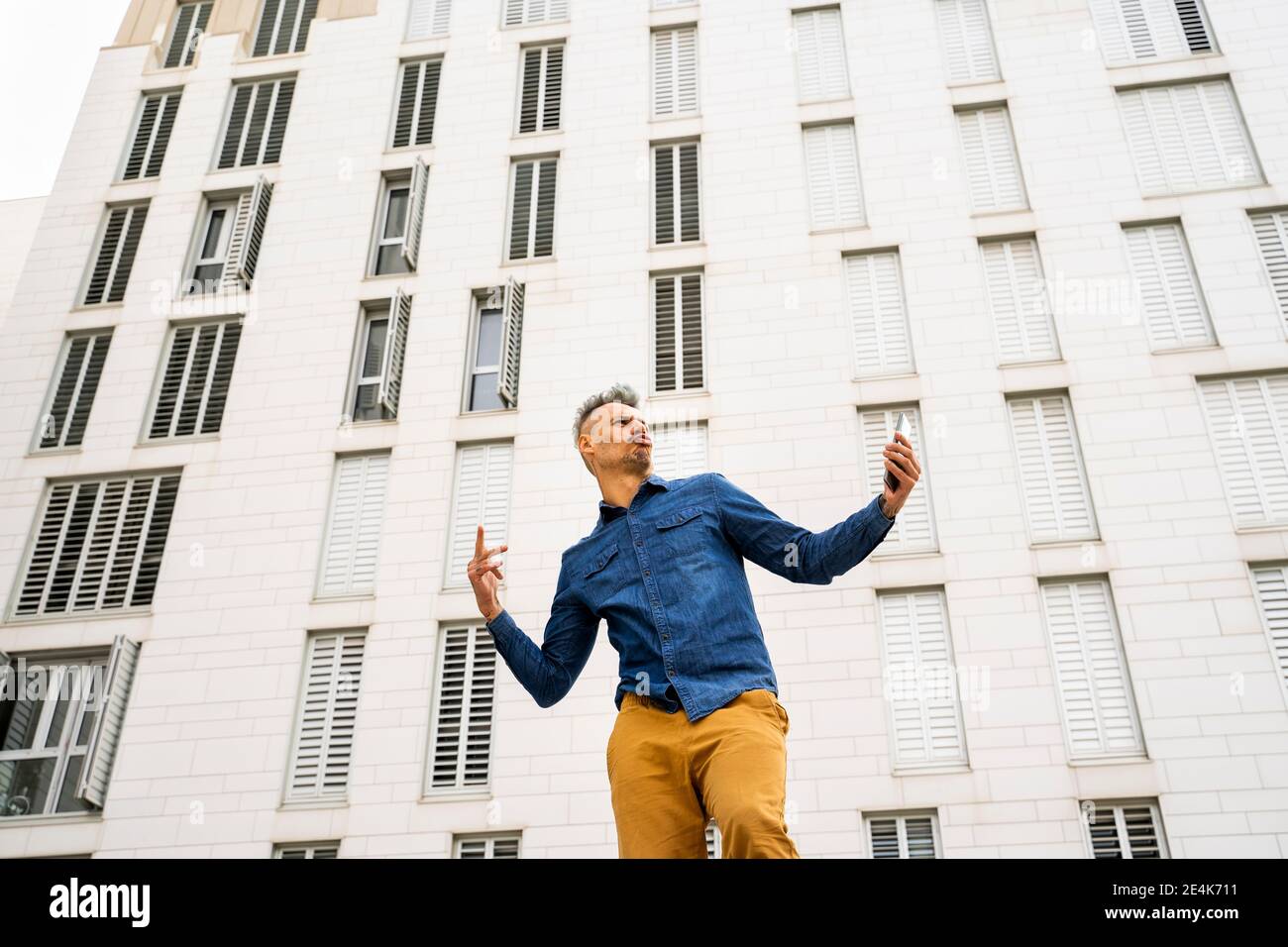 Man dancing against white building Stock Photo - Alamy