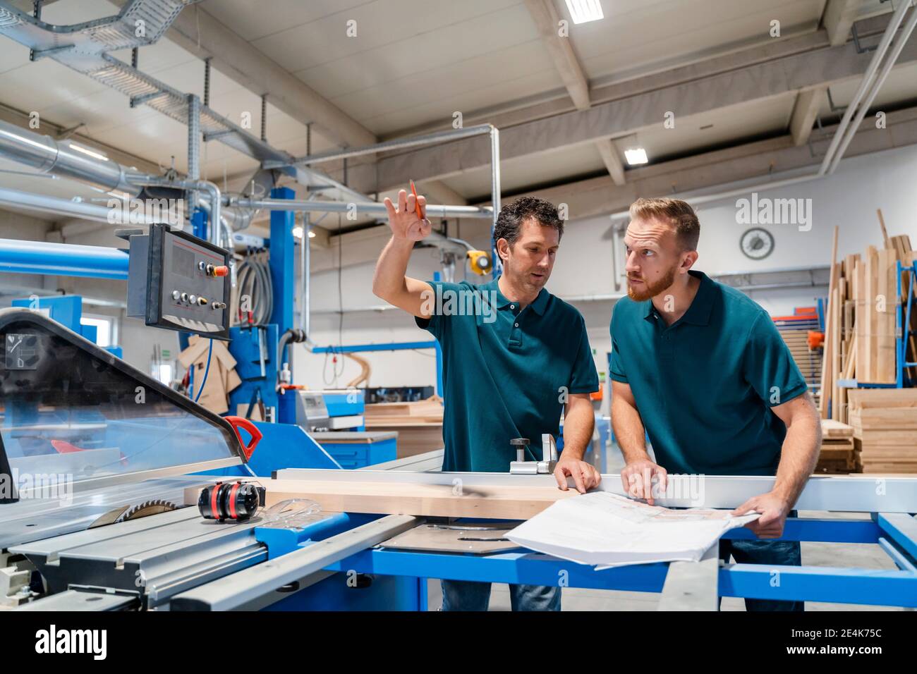 Two male carpenters working together in production hall Stock Photo - Alamy