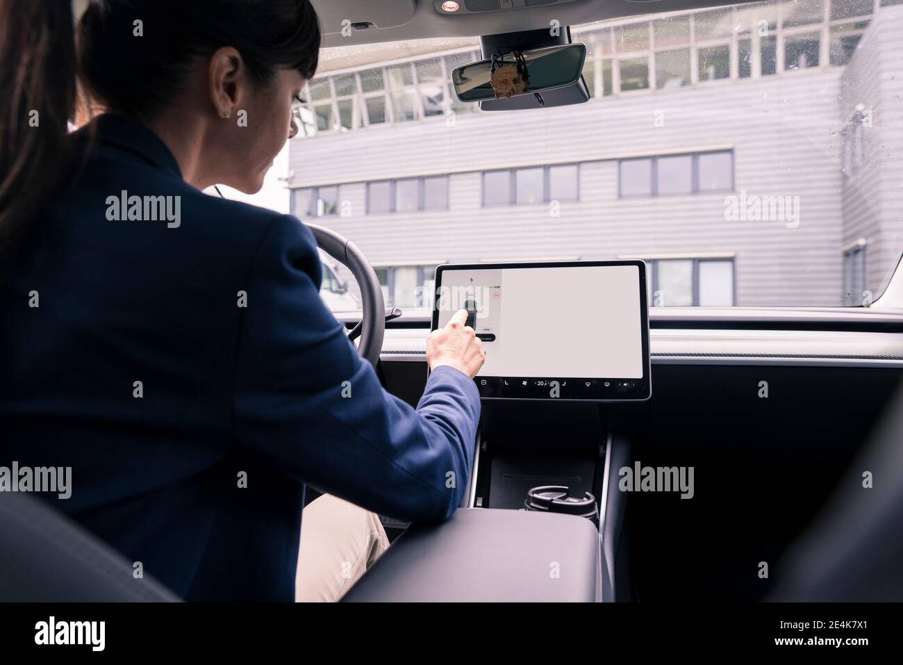 Female professional navigating through device while sitting in car ...