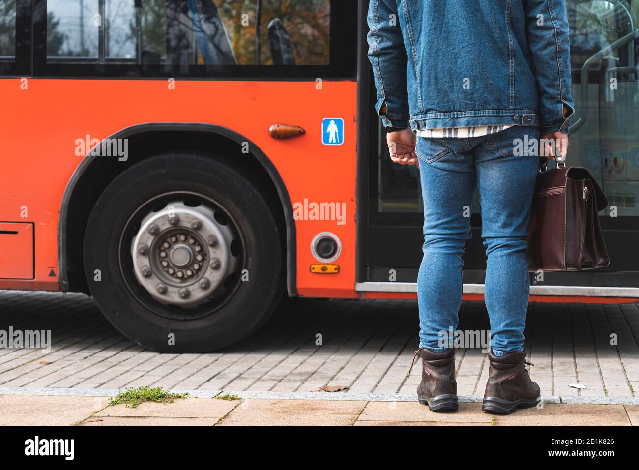 Commuter with briefcase about to enter bus Stock Photo - Alamy