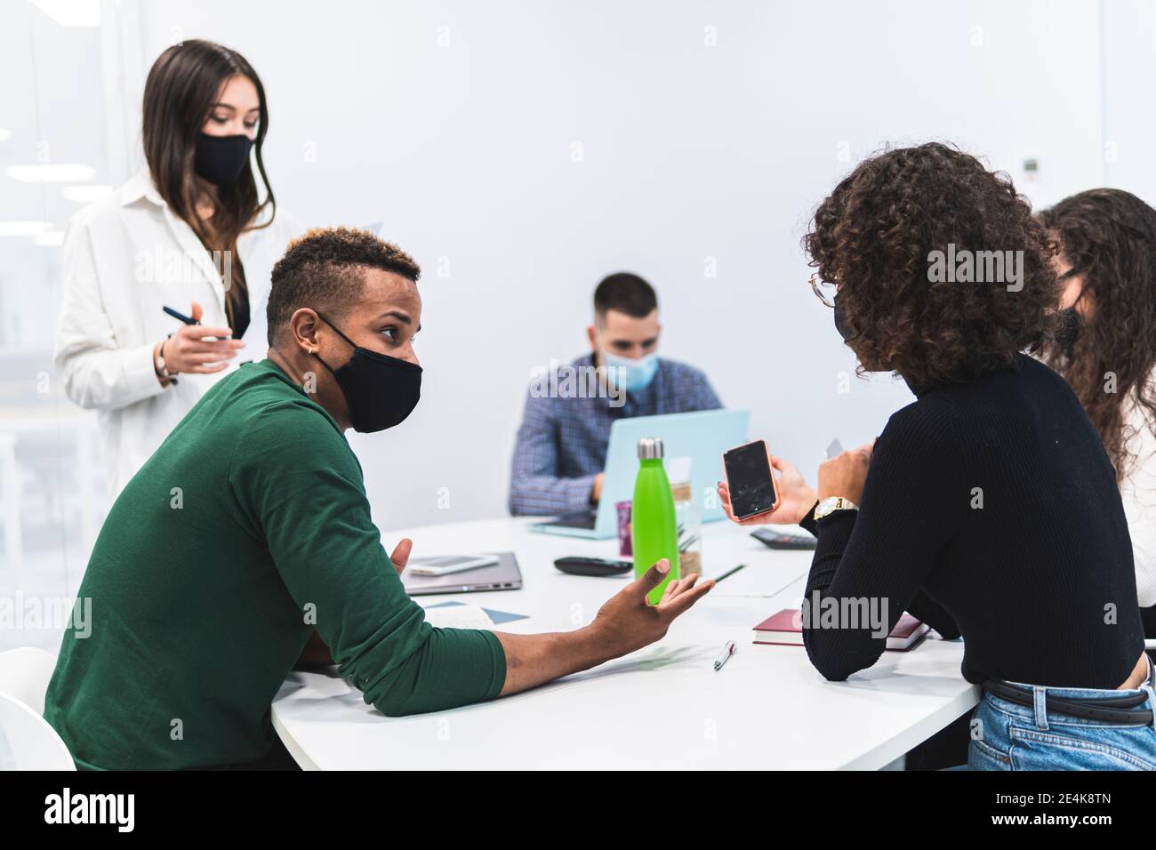 Male entrepreneur communicating with female coworker in board room at ...