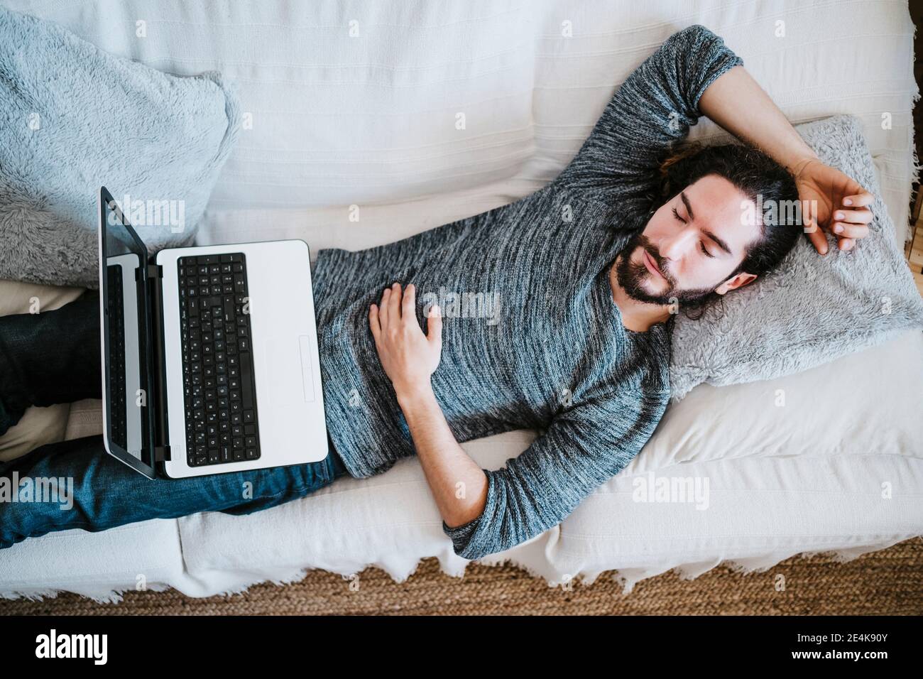 Man with laptop sleeping on sofa at home Stock Photo - Alamy