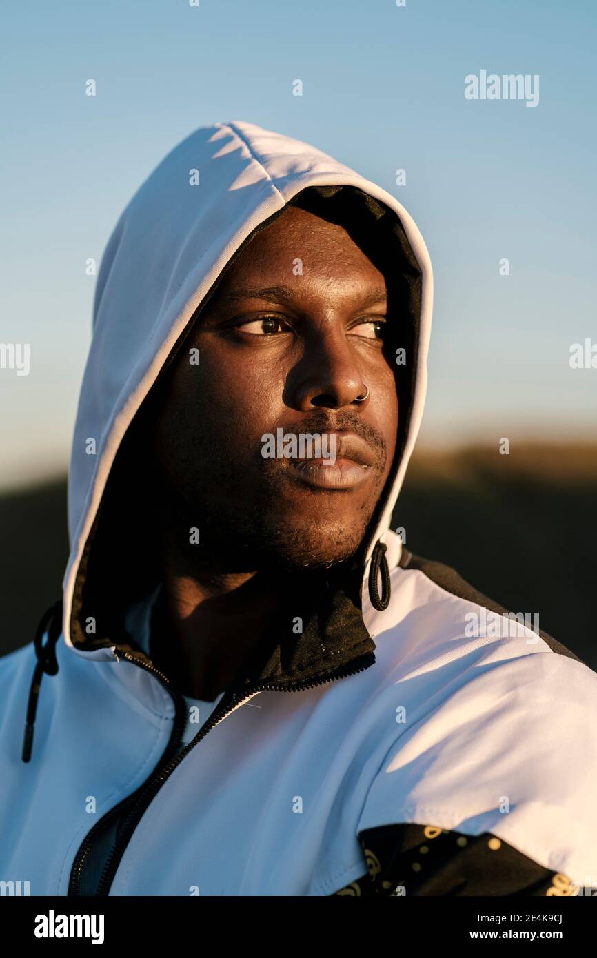 Portrait of adult man wearing white hood looking away Stock Photo - Alamy