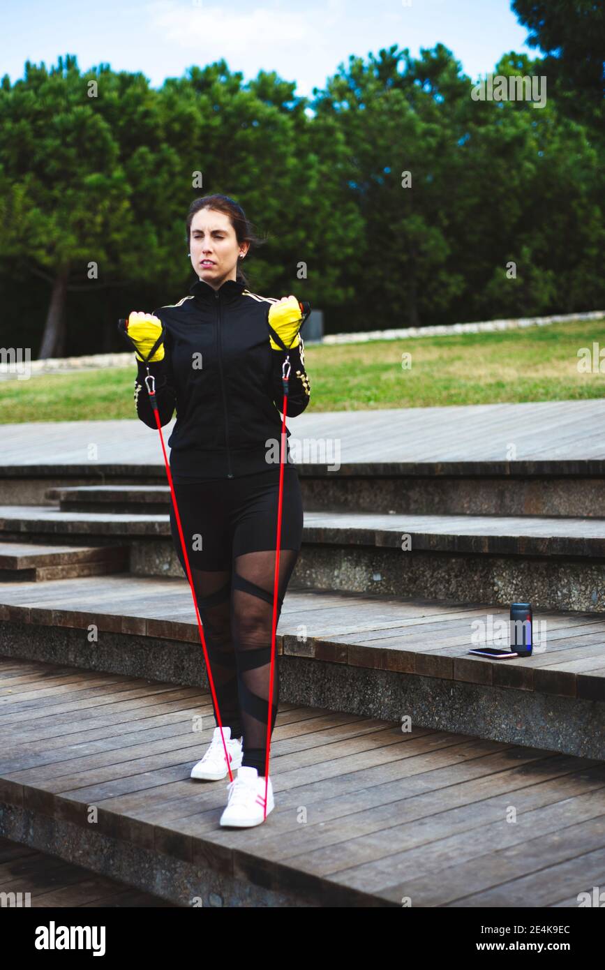 Young woman training with rubber bands to practice exercise. Sport ...
