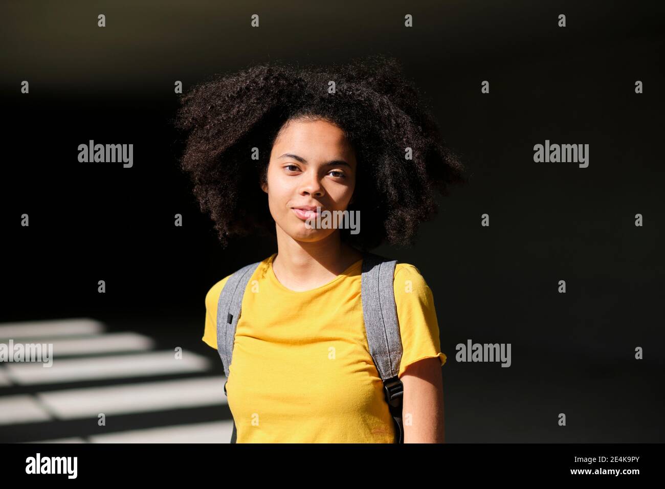 Young student carrying bag while standing at university corridor Stock ...