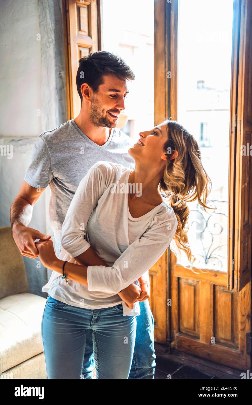 Affectionate young couple dancing at the window at home Stock Photo - Alamy