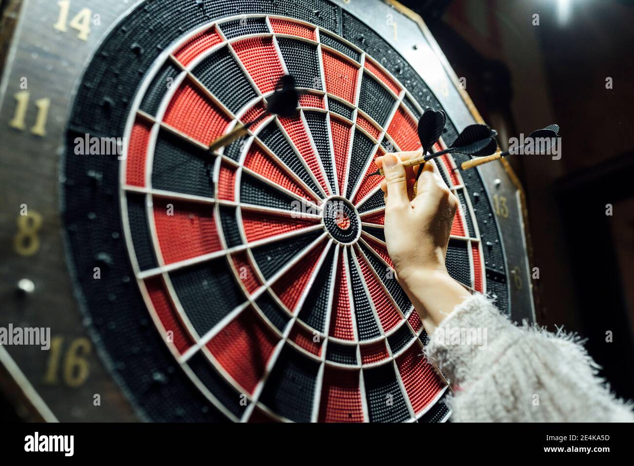 Woman's hand collecting darts from board Stock Photo - Alamy