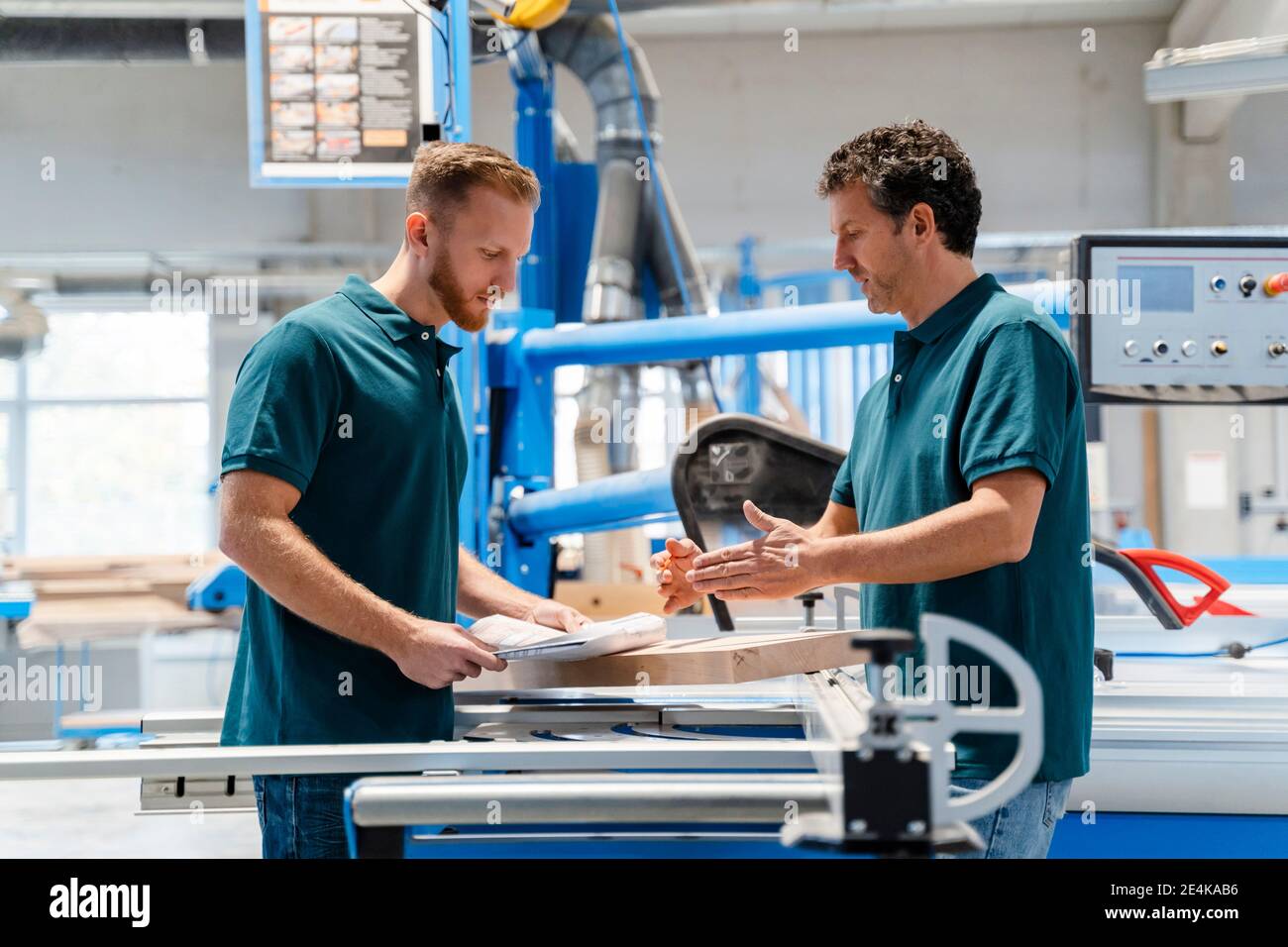 Two male carpenters working together in production hall Stock Photo - Alamy