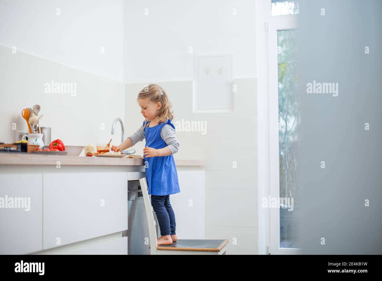 Girl standing on chair kitchen hi-res stock photography and images - Alamy