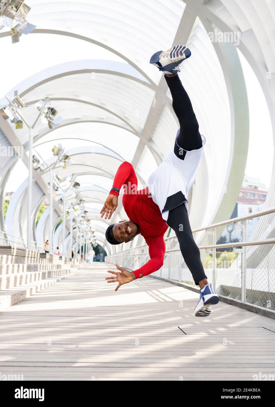 Acrobat smiling while jumping on walkway Stock Photo - Alamy