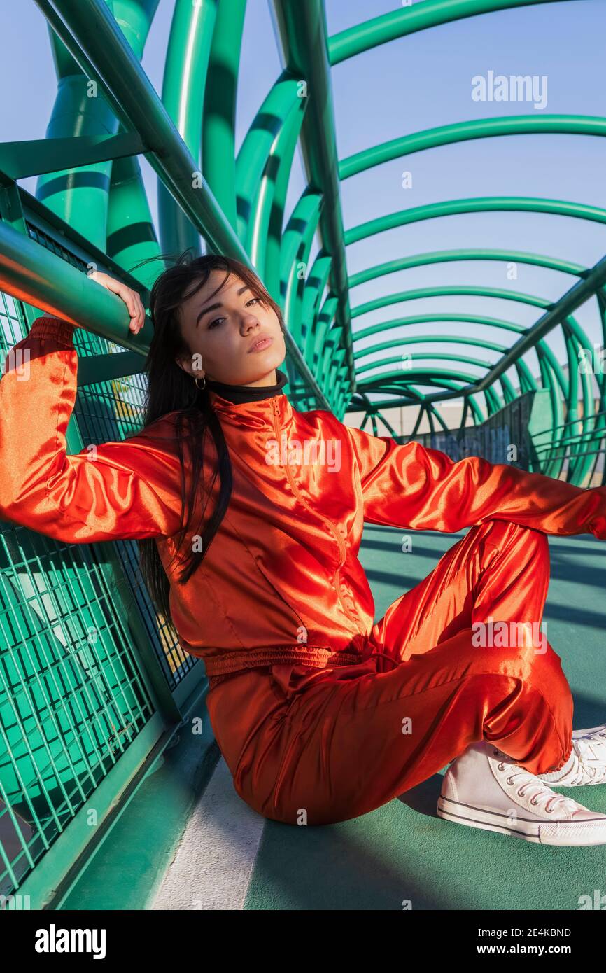 Young woman resting while leaning on bridge railing Stock Photo - Alamy