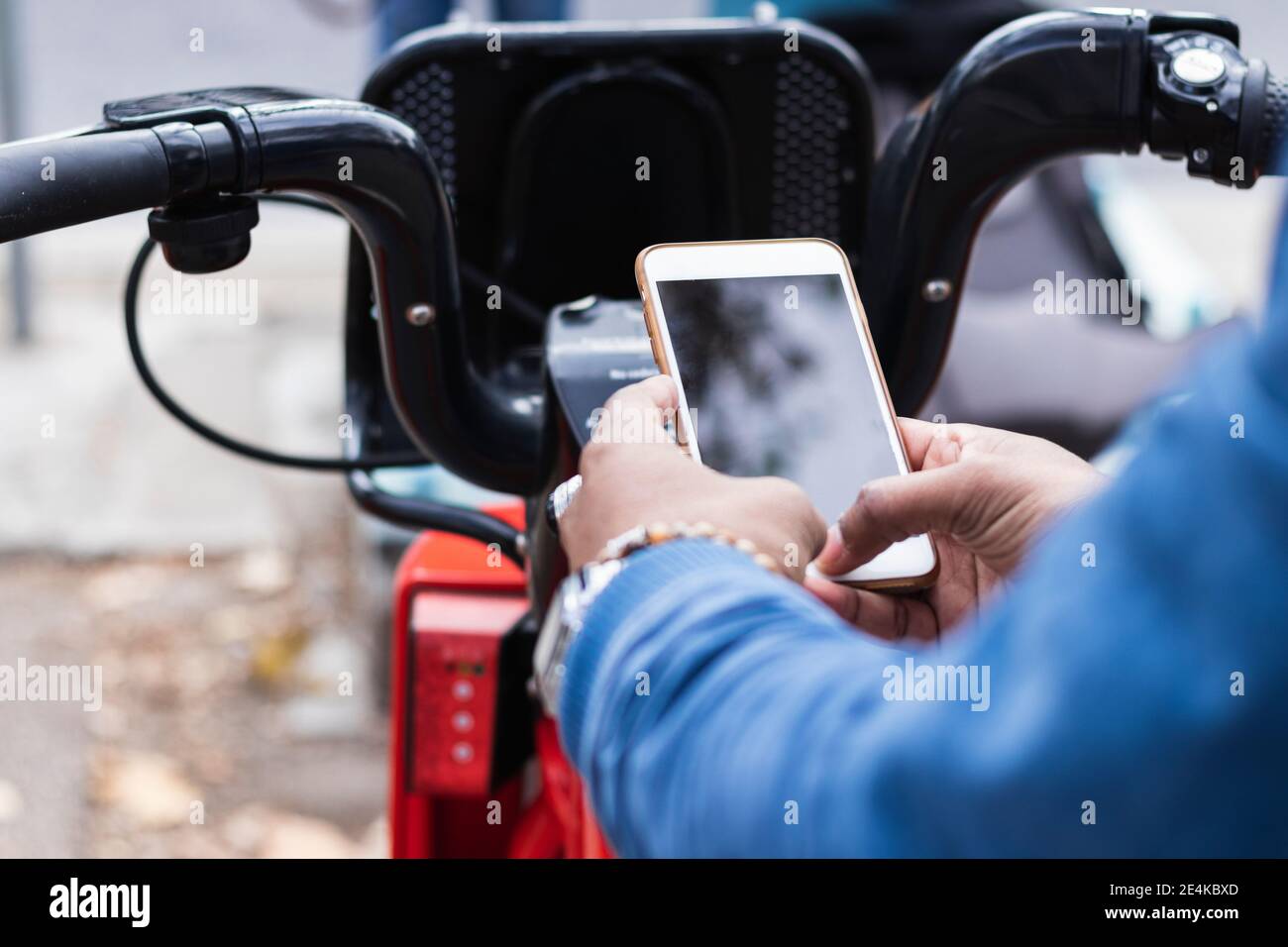 Hands of man using smart phone for renting bicycle at parking station ...