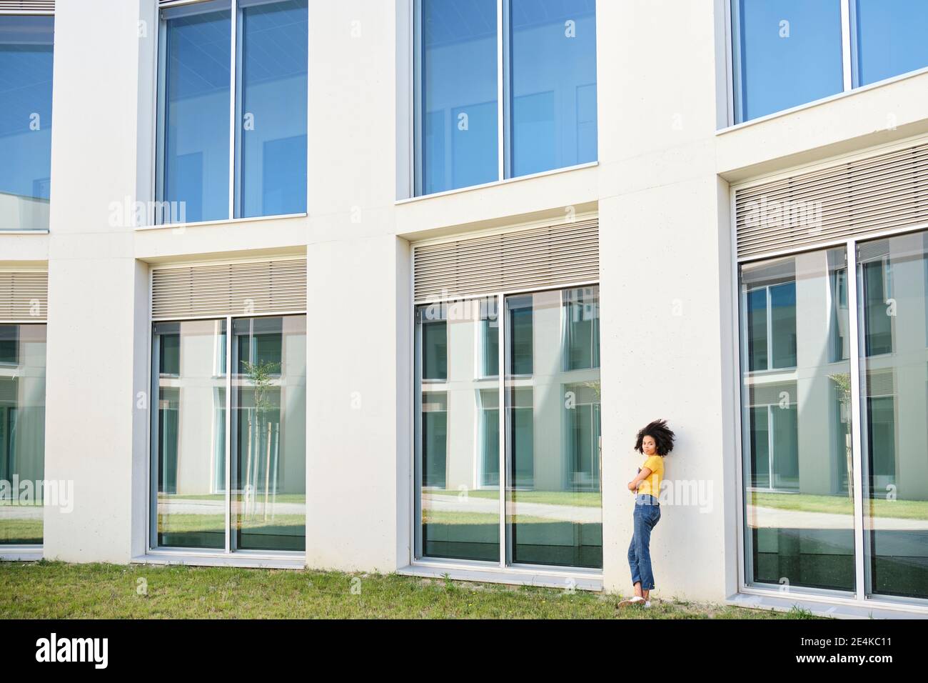 Female student leaning on wall at university campus Stock Photo - Alamy