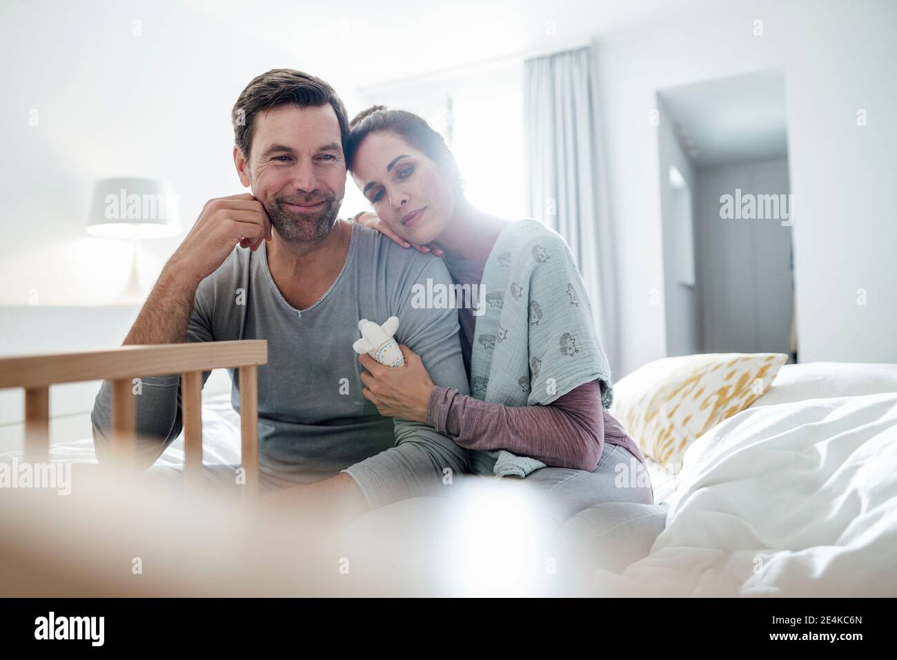 Mature couple admiring crib in bedroom Stock Photo - Alamy