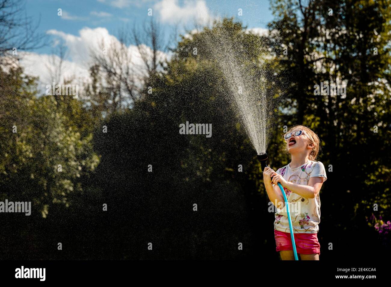 Girl holding water hose hi-res stock photography and images - Alamy