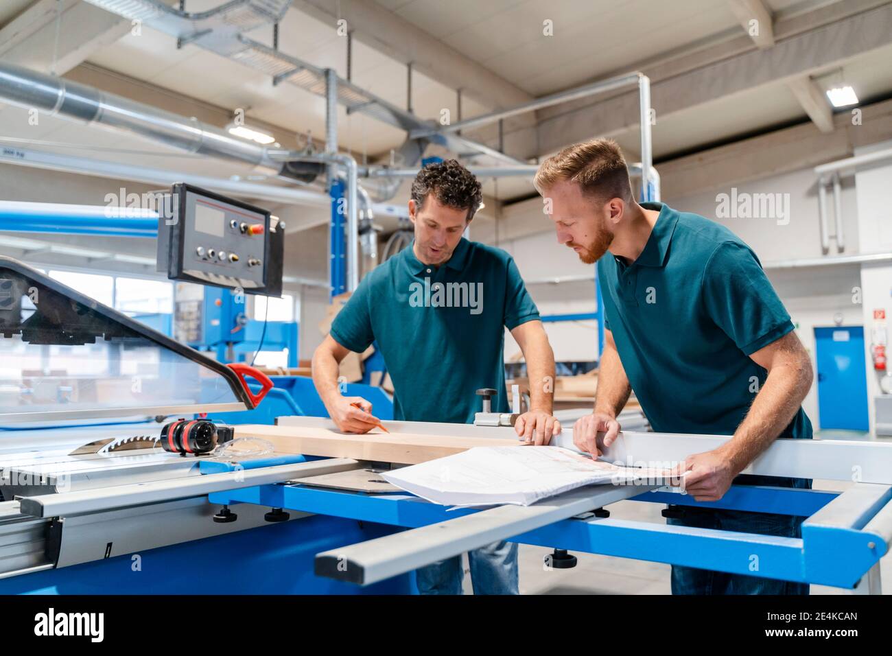 Two male carpenters working together in production hall Stock Photo - Alamy
