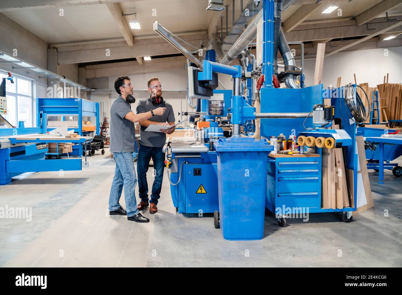 Two male carpenters talking in production hall Stock Photo - Alamy