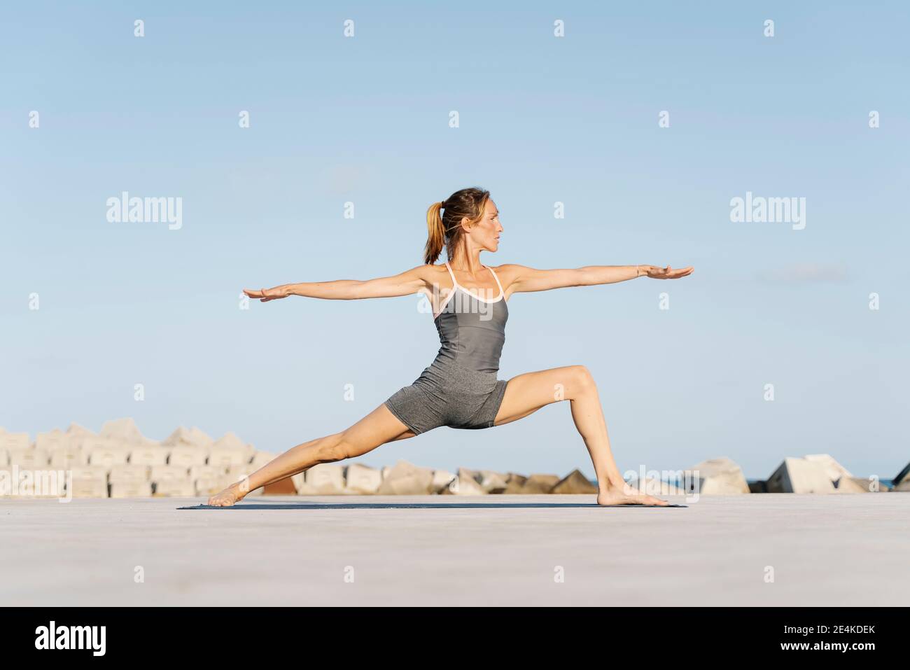 Female sportsperson doing warrior position on exercise mat Stock Photo ...