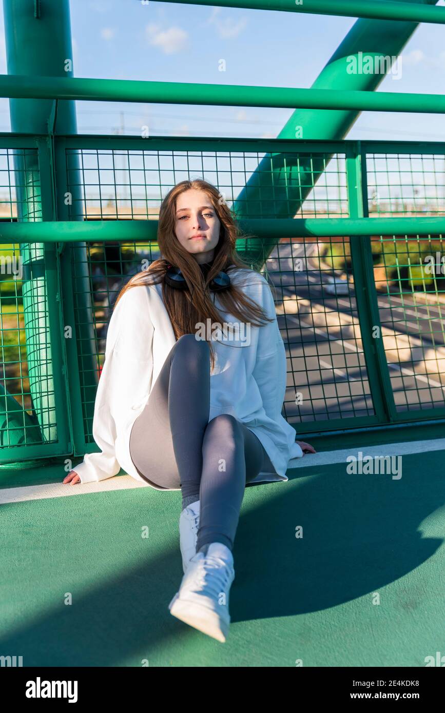 Teenage girl resting while leaning on bridge railing Stock Photo - Alamy