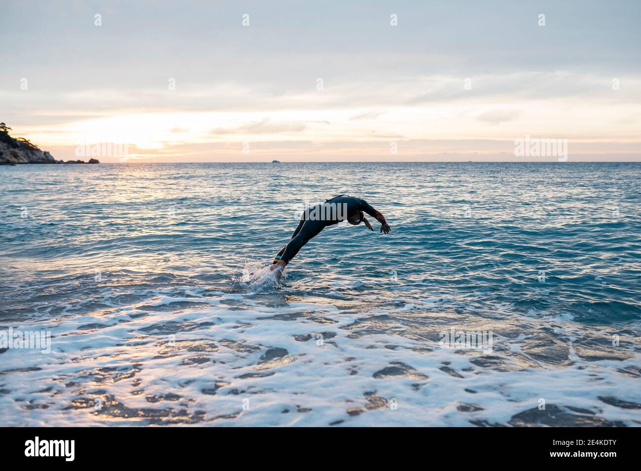 Male swimmer jumping into sea water Stock Photo - Alamy