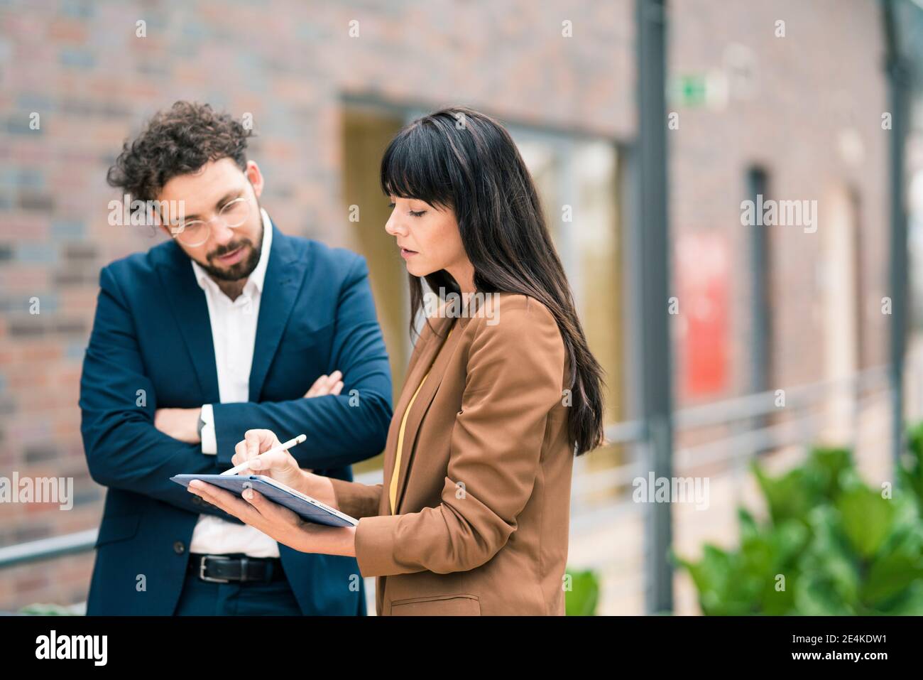 Female entrepreneur with digital tablet explaining male colleague at ...
