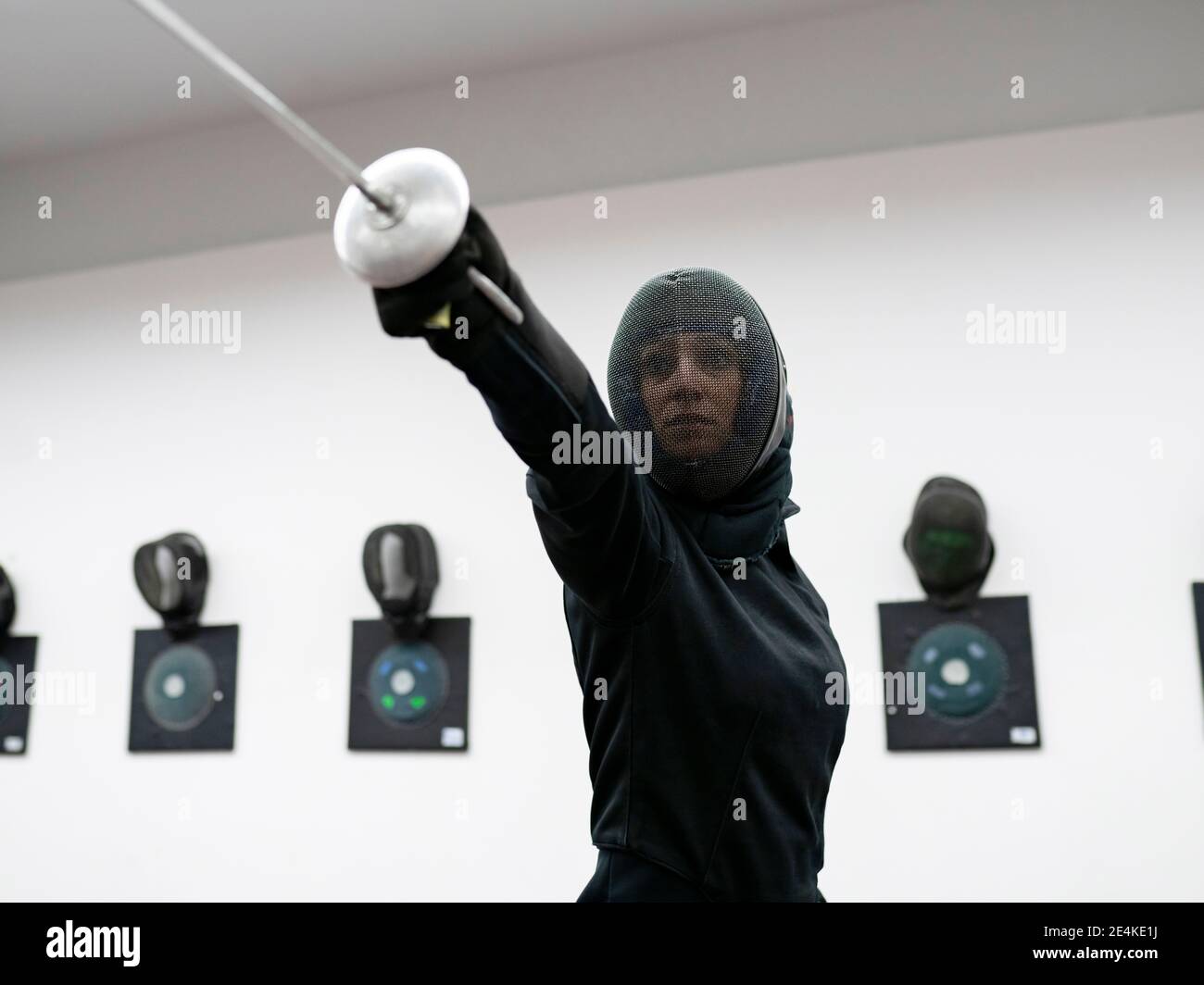 Woman in fencing outfit practicing at gym Stock Photo - Alamy