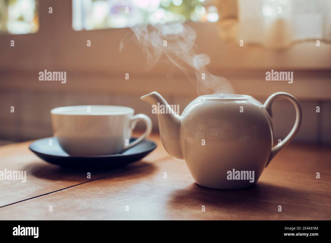 Teapot giving off smoke on top of kitchen table Stock Photo - Alamy